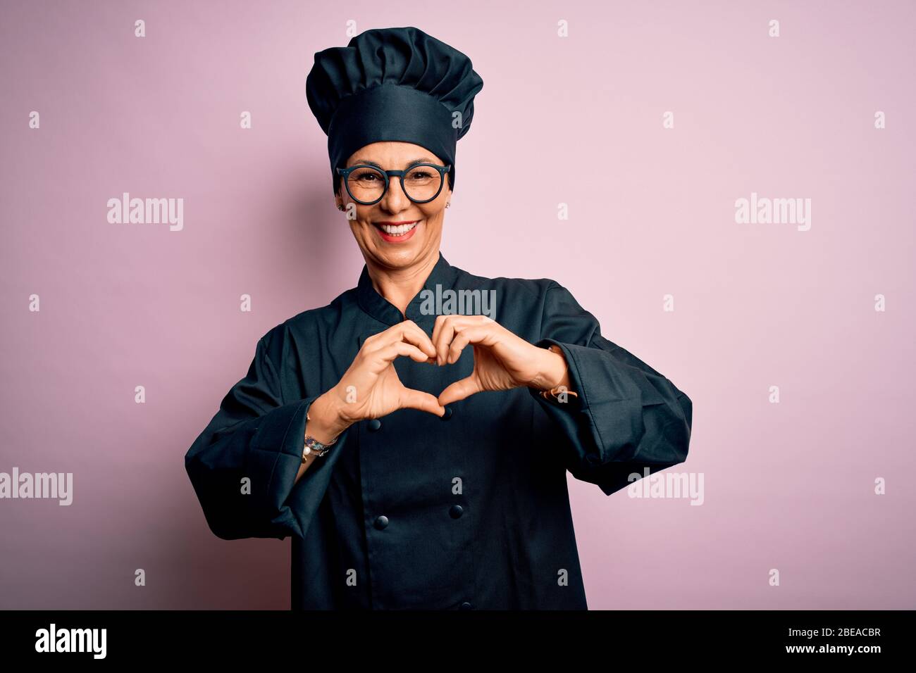 Middle age brunette chef woman wearing cooker uniform and hat over ...