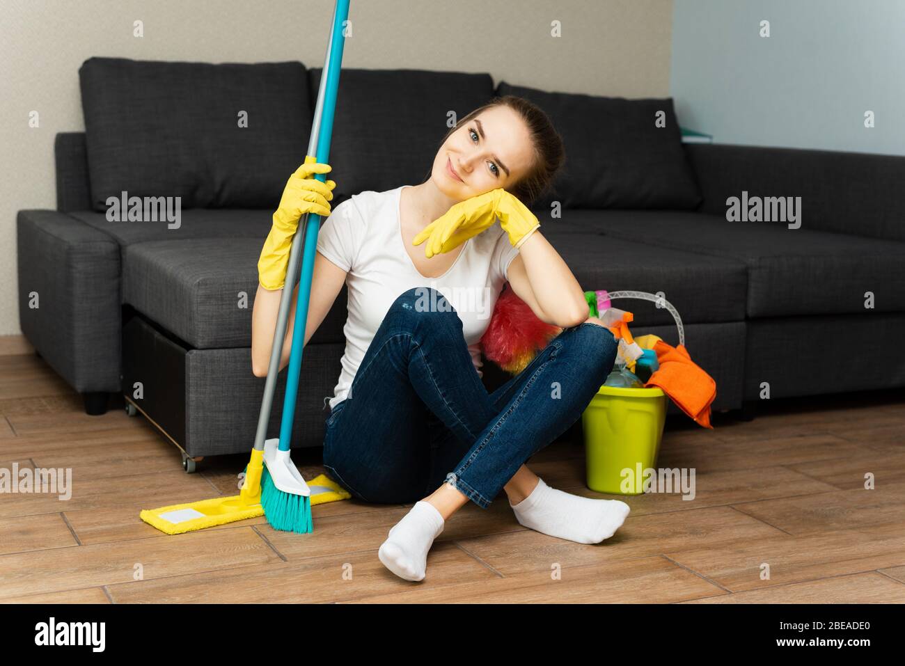 A girl is holding detergents in a bucket on the background. Woman is ...