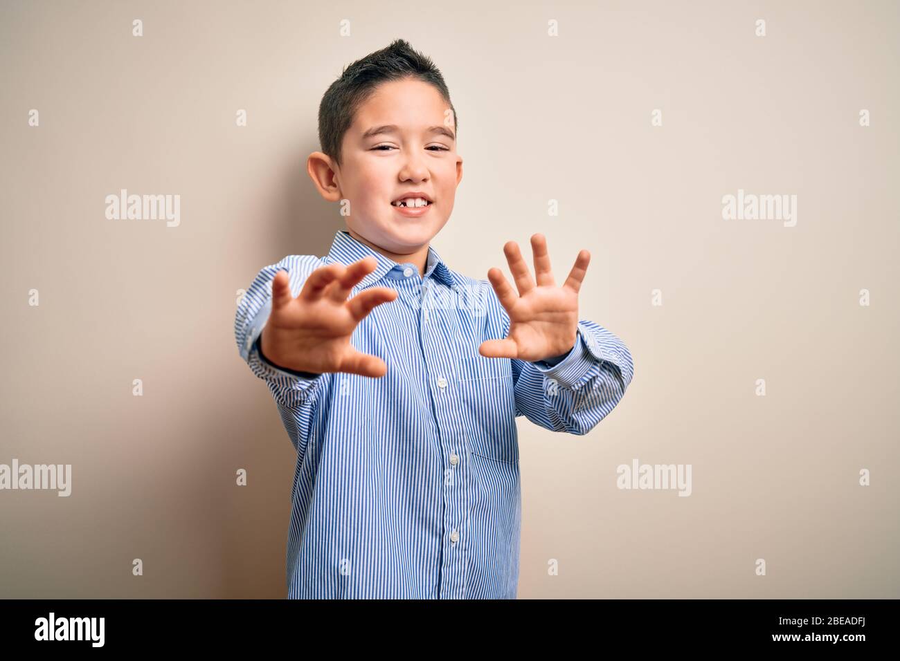 Young little boy kid wearing elegant shirt standing over isolated ...