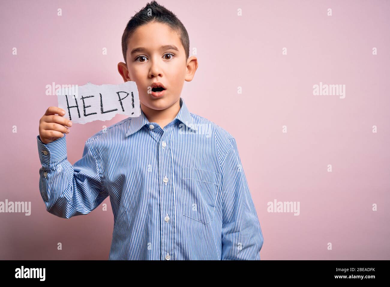 Young little boy kid holding paper sing with help message asking for ...