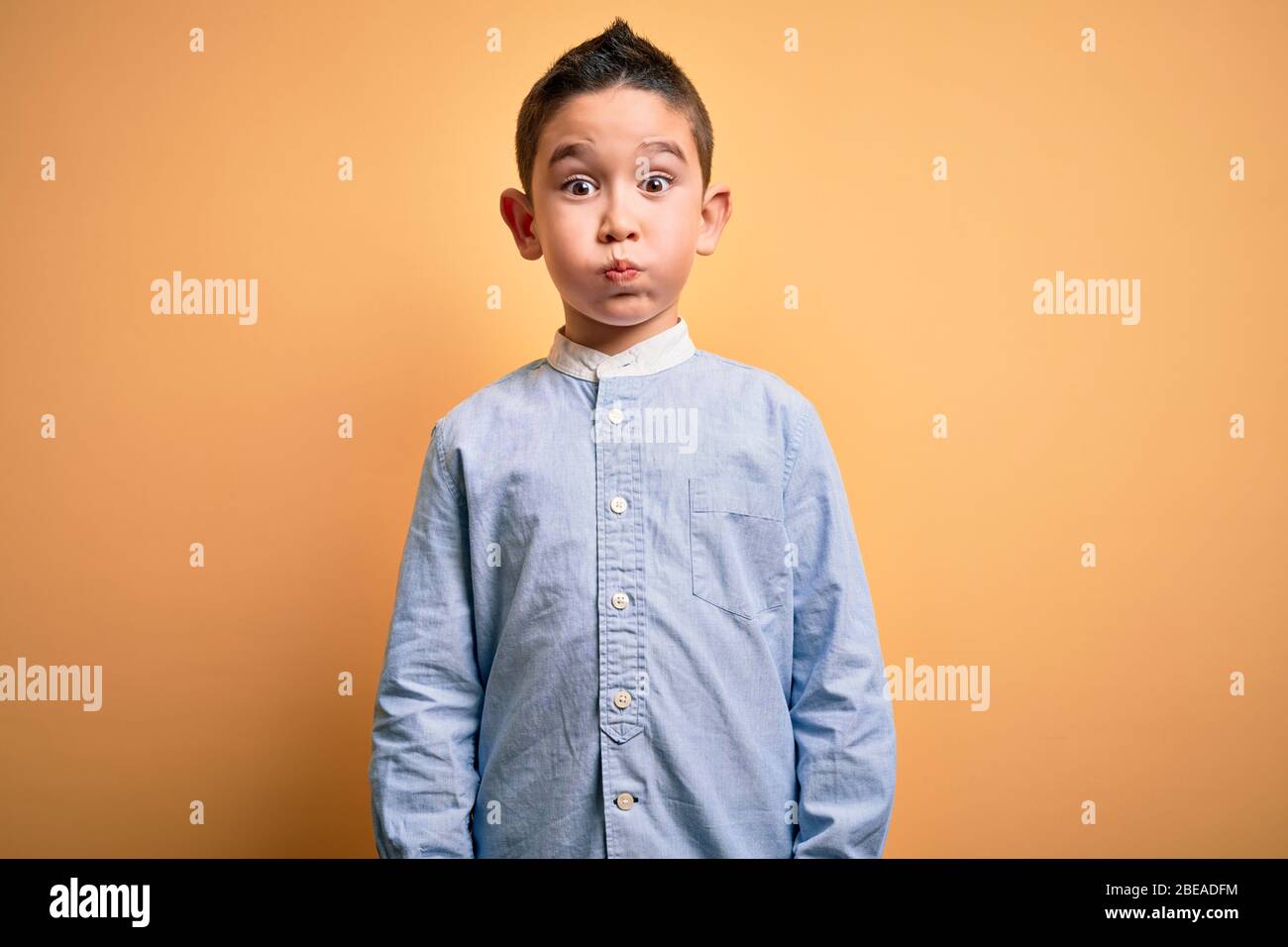 Young little boy kid wearing elegant shirt standing over yellow ...