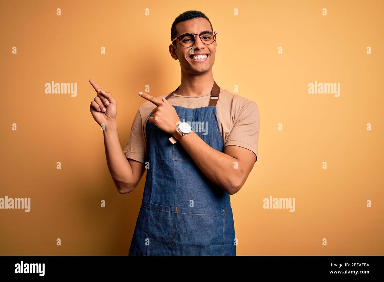 Young handsome african american shopkeeper man wearing apron over ...