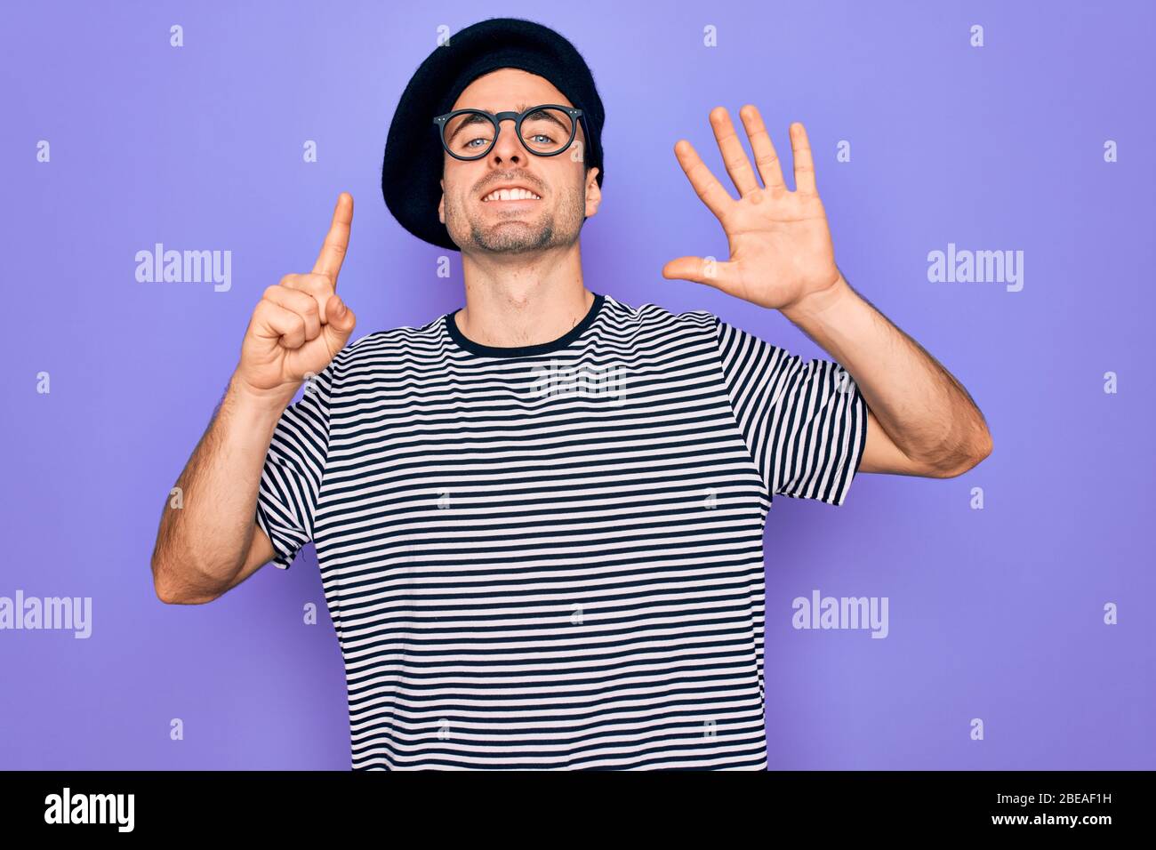 Handsome man with blue eyes wearing striped t-shirt and french beret ...