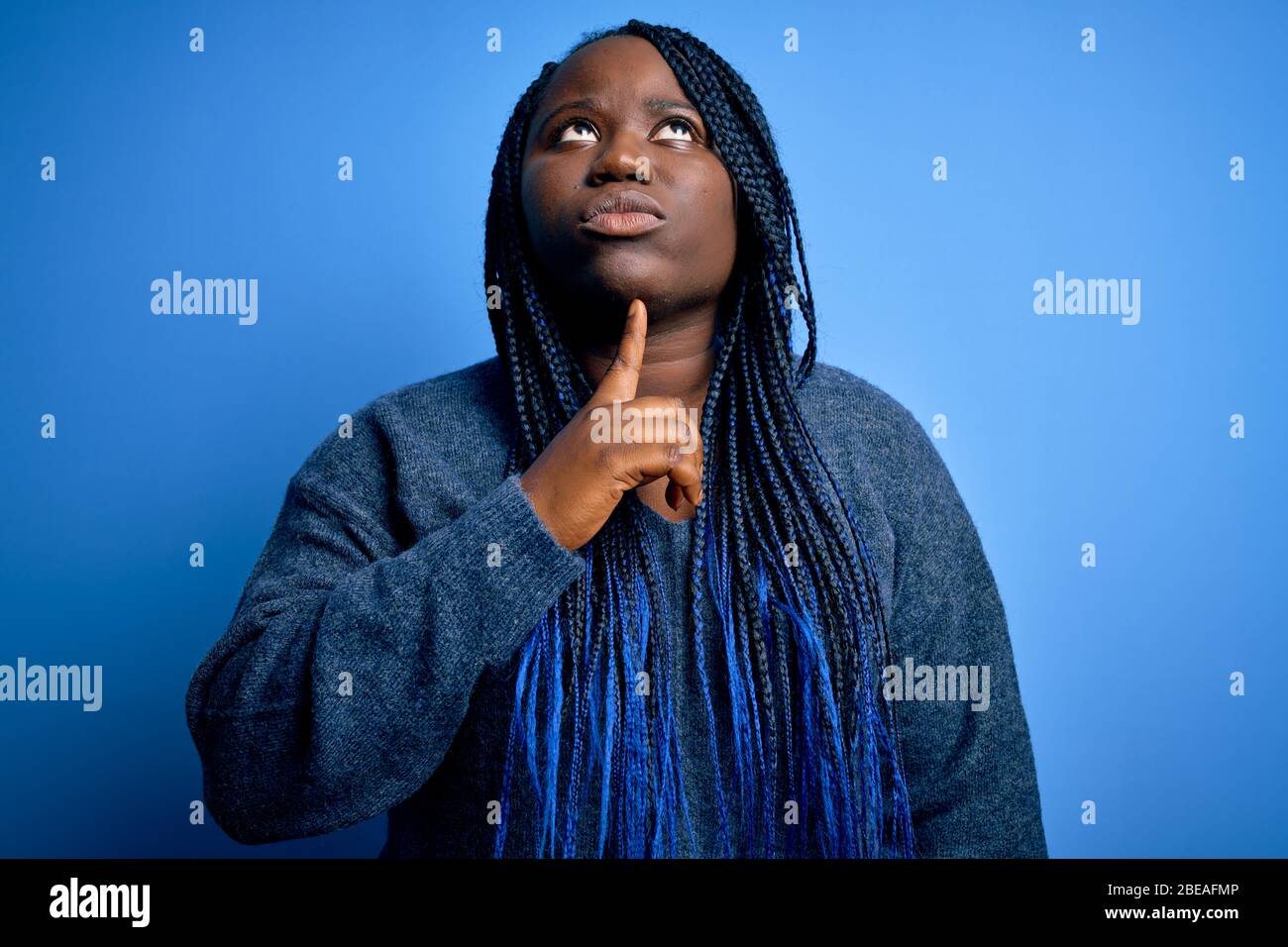 African american plus size woman with braids wearing casual sweater ...