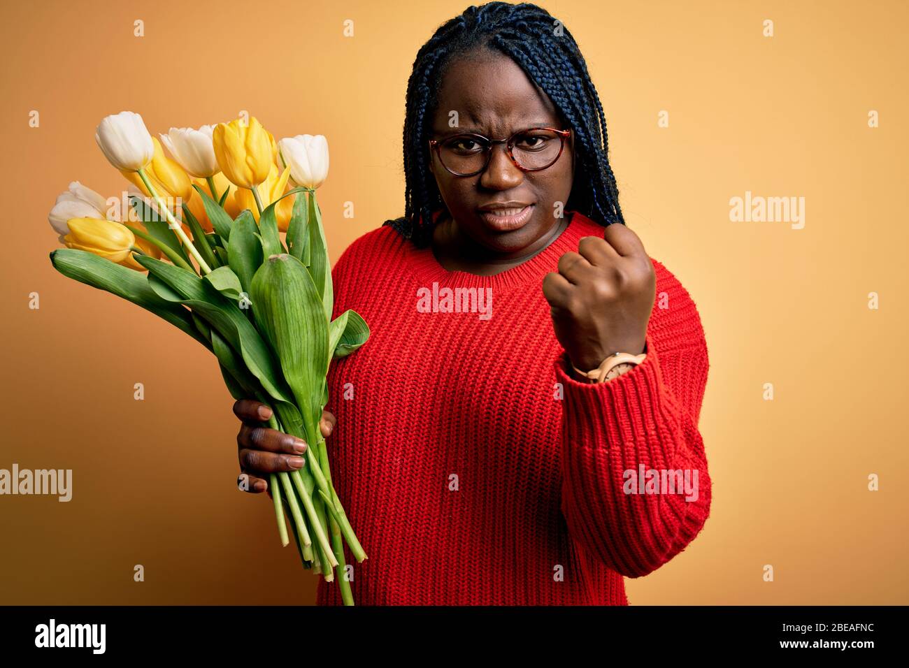 Young african american plus size woman with braids holding bouquet of ...
