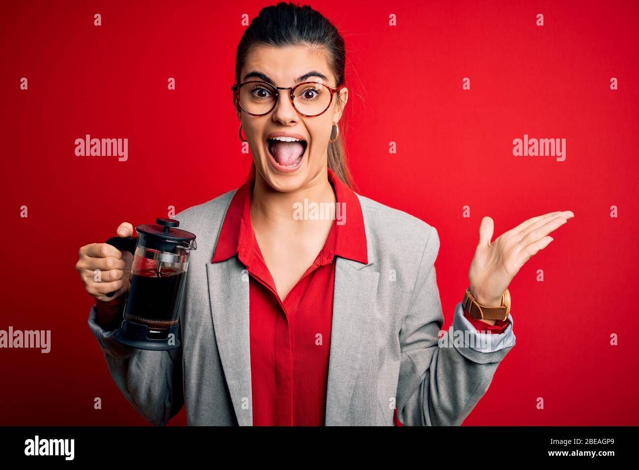 Young beautiful brunette woman doing coffe holding french coffeemaker ...