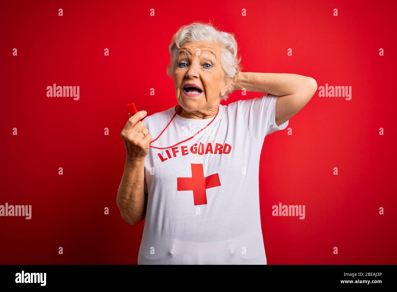 Senior beautiful grey-haired lifeguard woman wearing t-shirt with red ...
