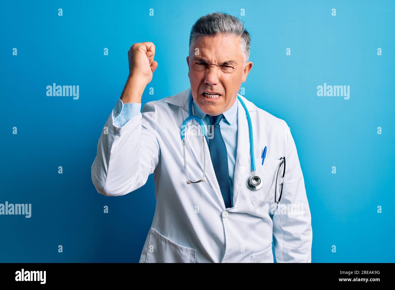 Middle age handsome grey-haired doctor man wearing coat and blue ...