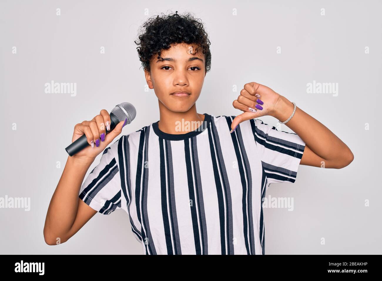 Beautiful african american afro singer woman singing using microphone ...
