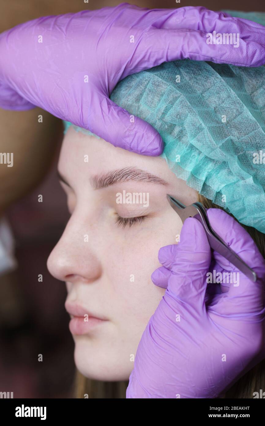Eyebrow correction with tweezers. Final stage of creating perfect shape ...