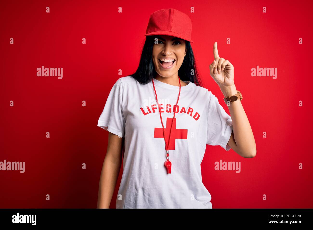 Young beautiful hispanic lifeguard woman wearing safeguard t-shirt and ...