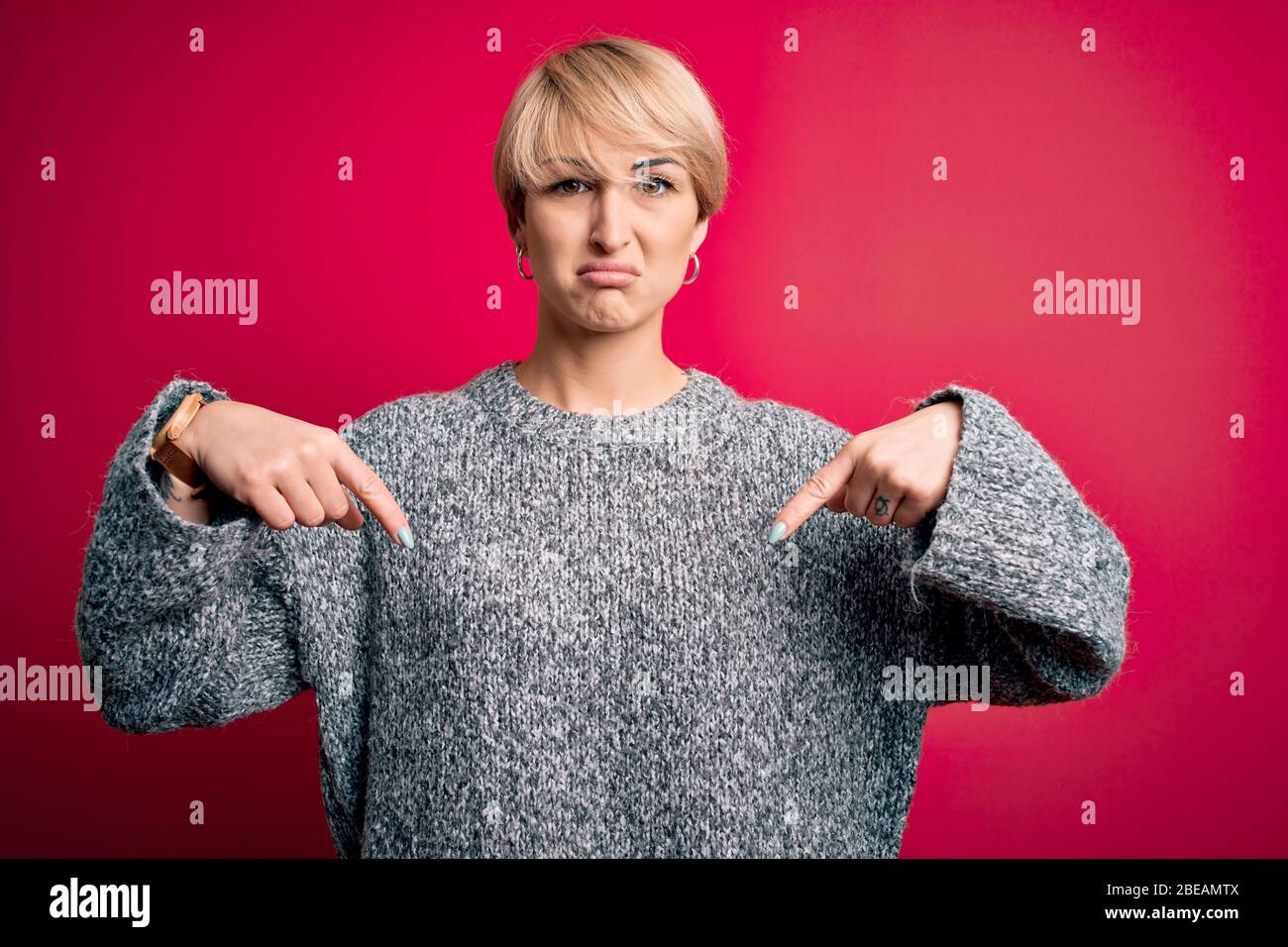 Young blonde woman with modern short hair wearing casual sweater over ...