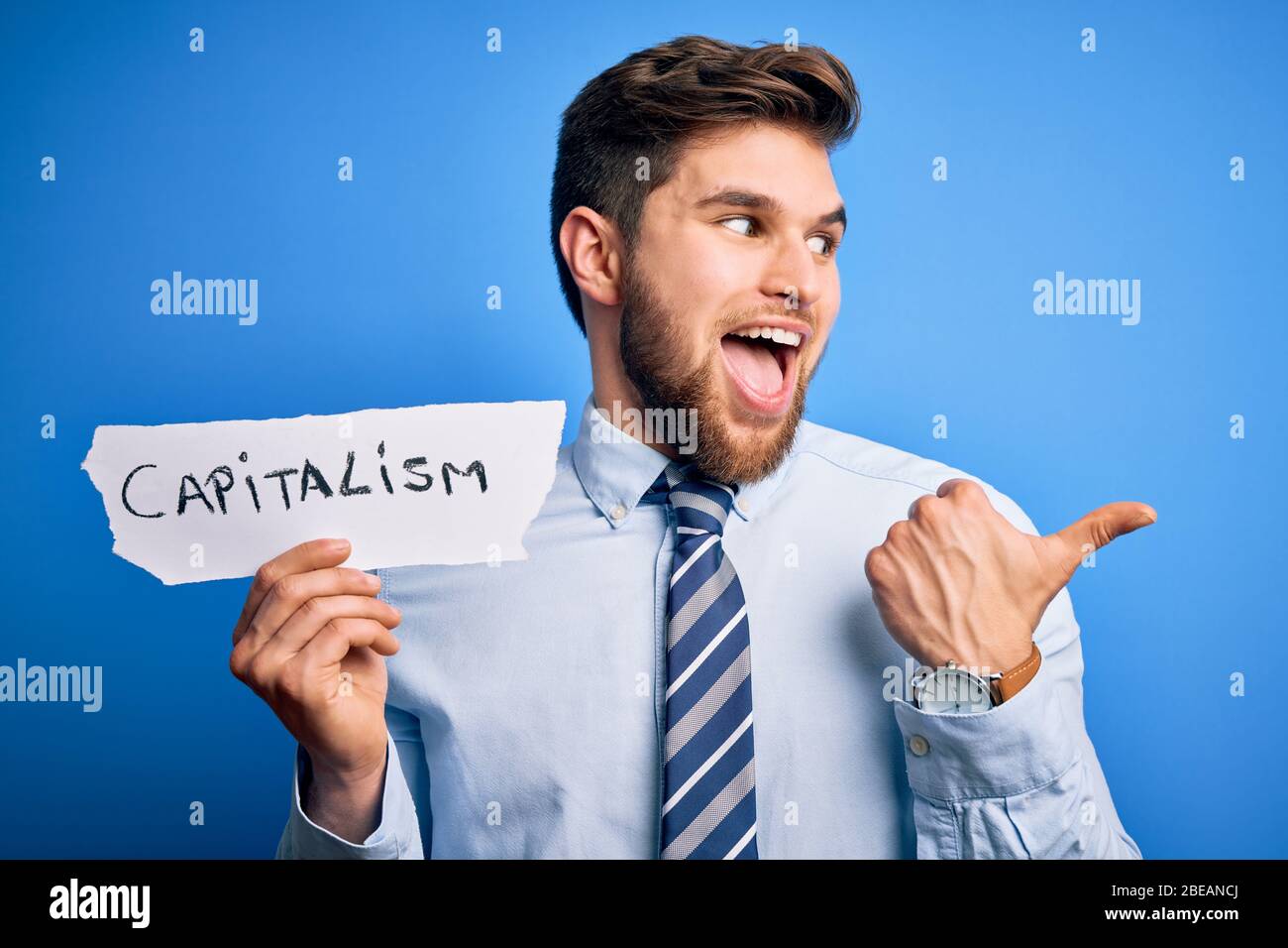Young blond businessman with beard and blue eyes holding paper with ...