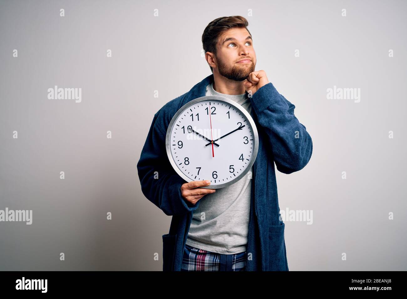 Young blond man with beard and blue eyes wearing pajama holding big ...