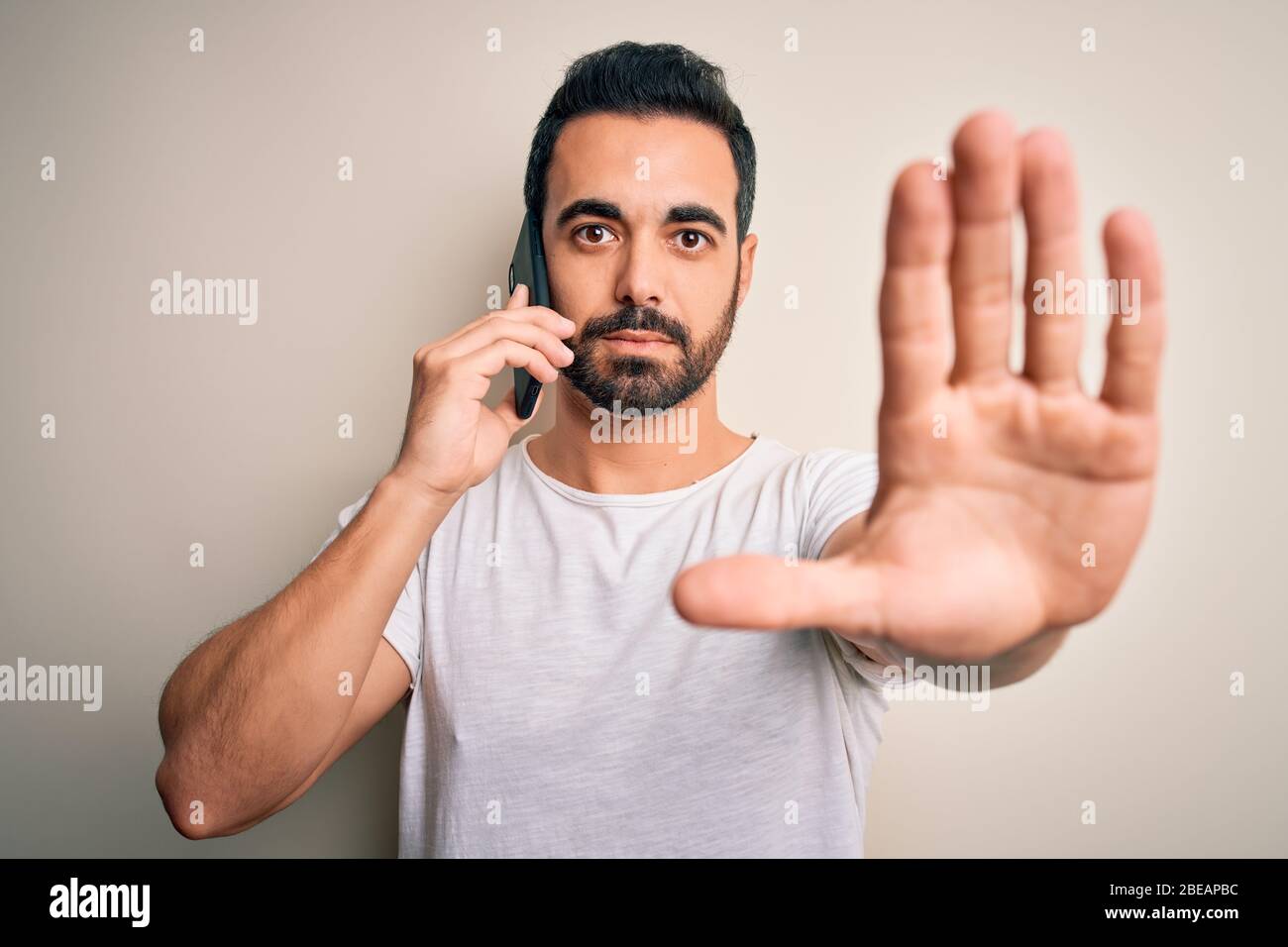 Young handsome man with beard having conversation talking on the ...