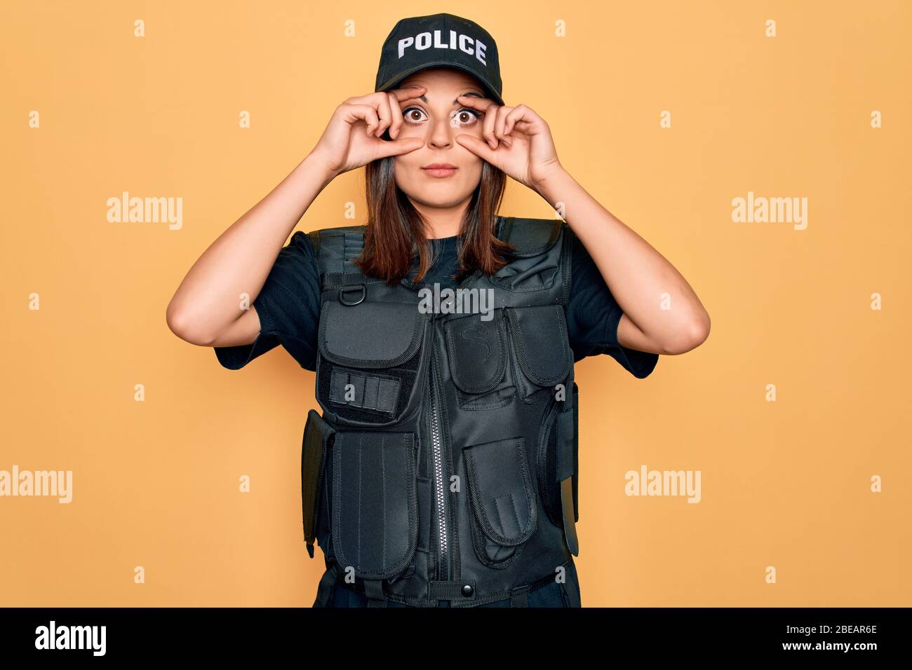 Young beautiful brunette policewoman wearing police uniform bulletproof ...