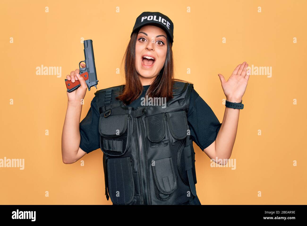 Young beautiful brunette policewoman wearing police uniform bulletproof ...