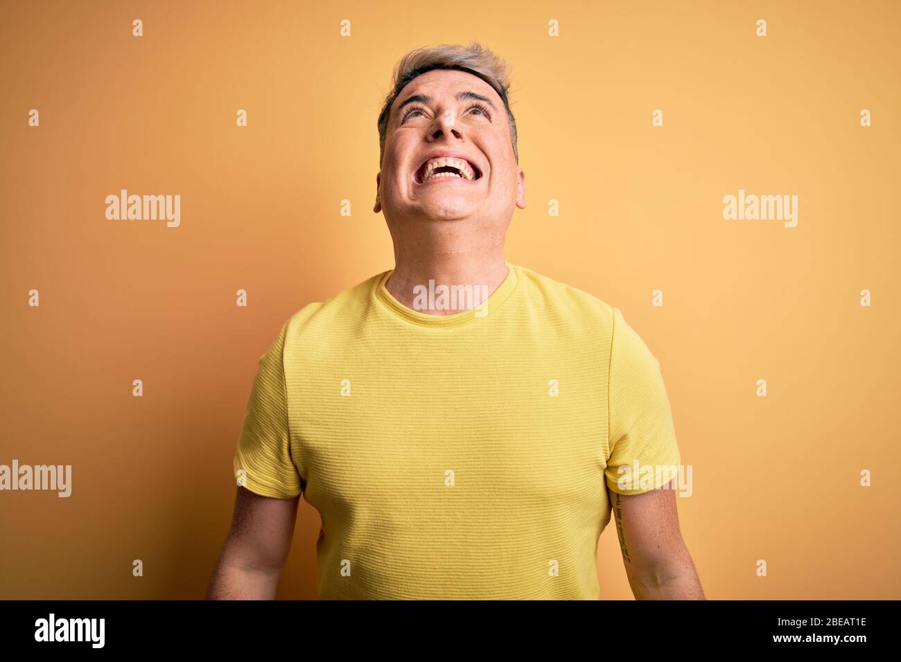 Young handsome modern man wearing yellow shirt over yellow isolated ...
