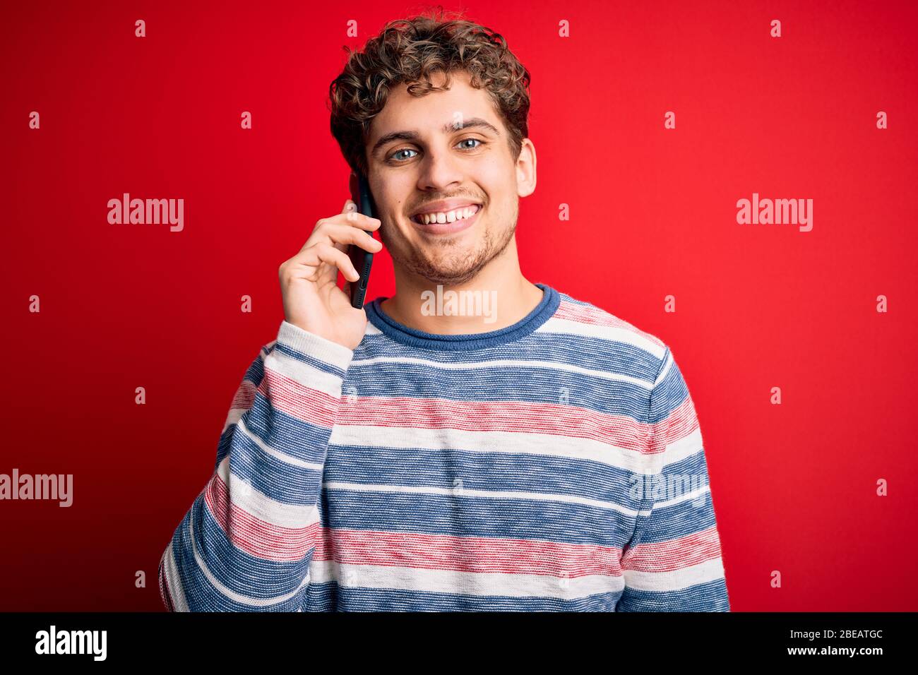 Young blond man with curly hair having conversation talking by the ...