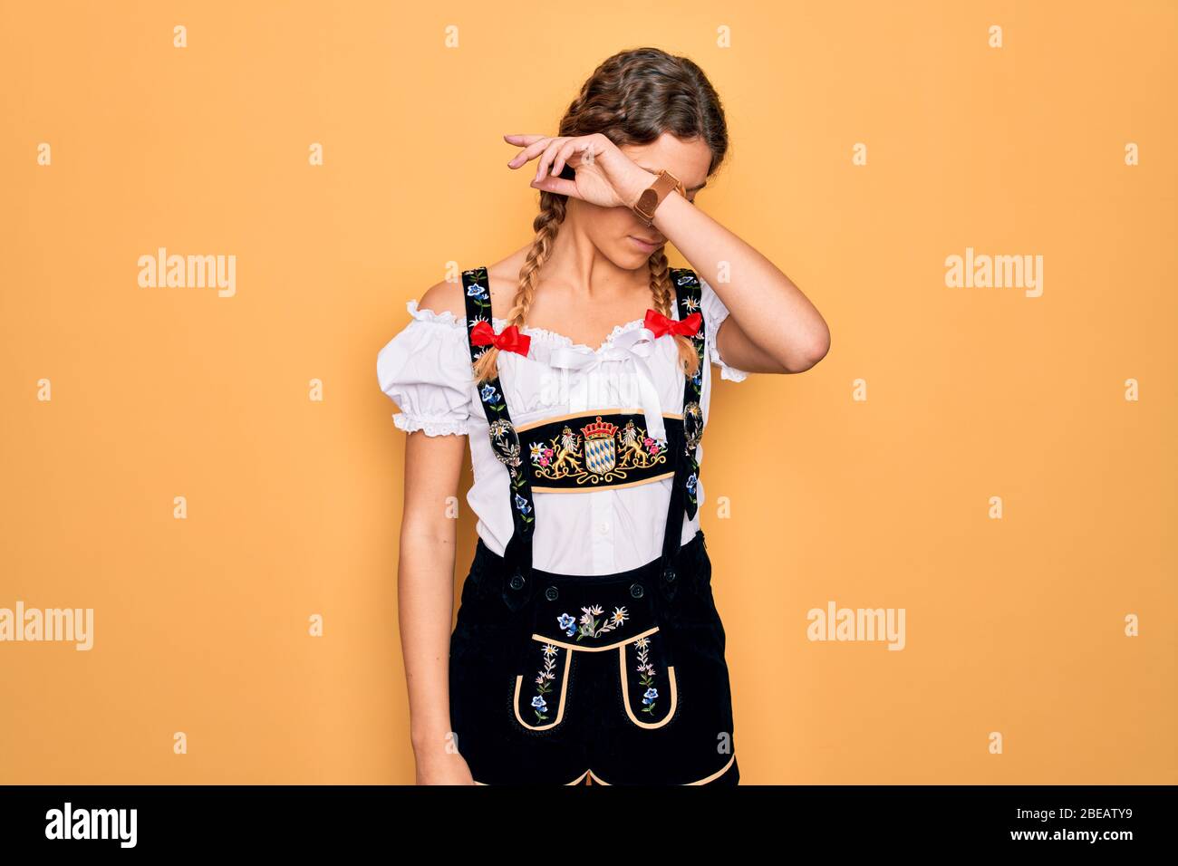 Young beautiful blonde german woman with blue eyes wearing traditional ...