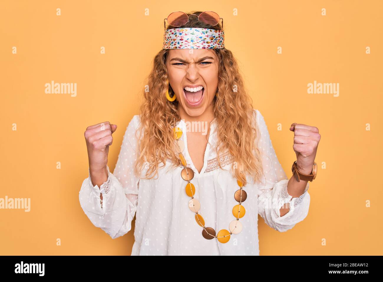 Young beautiful blonde hippie woman with blue eyes wearing sunglasses ...