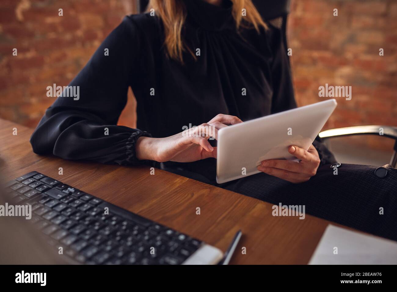 Using tablet, close up, copyspace. Caucasian young woman in business ...