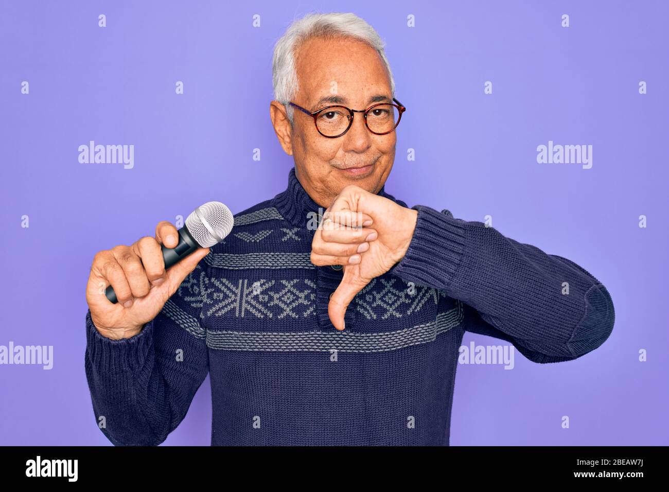 Middle age senior grey-haired singer man singing using music microphone ...
