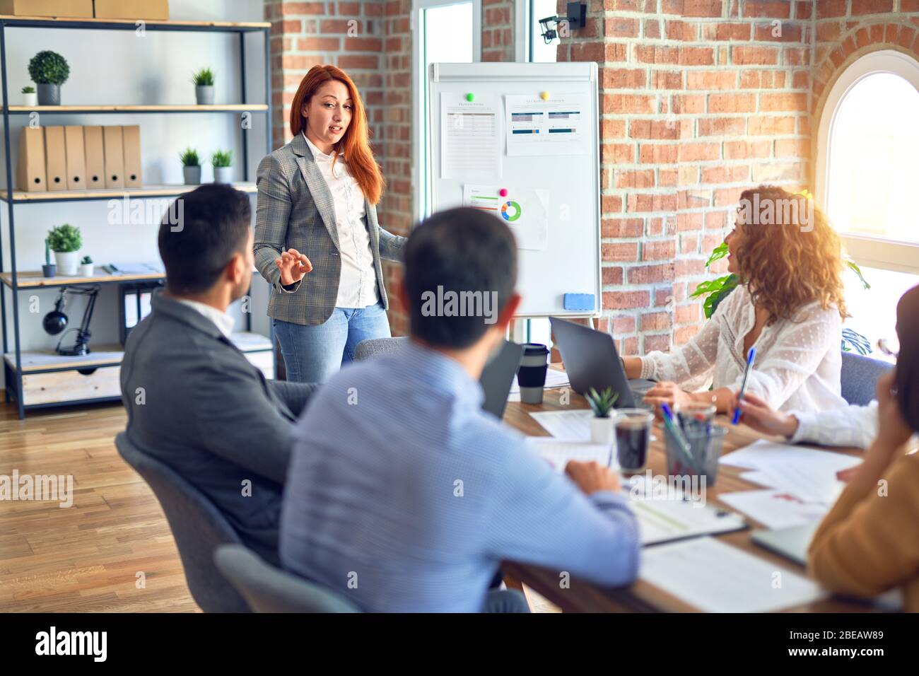 Group of business workers working together in a meeting. One of them ...