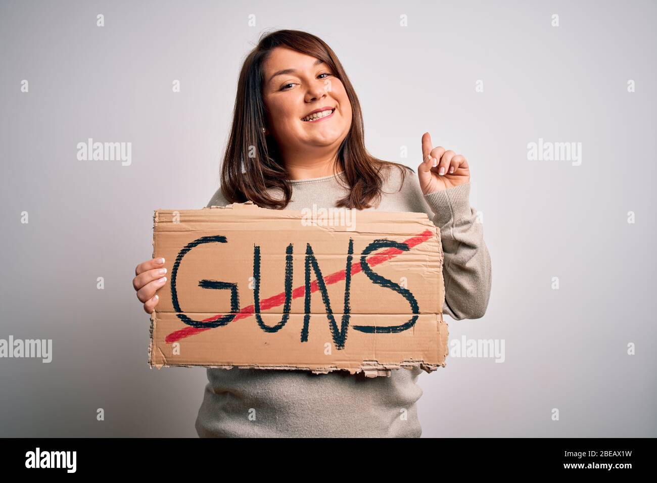 Plus size woman holding stop guns cardboard banner warning about ...