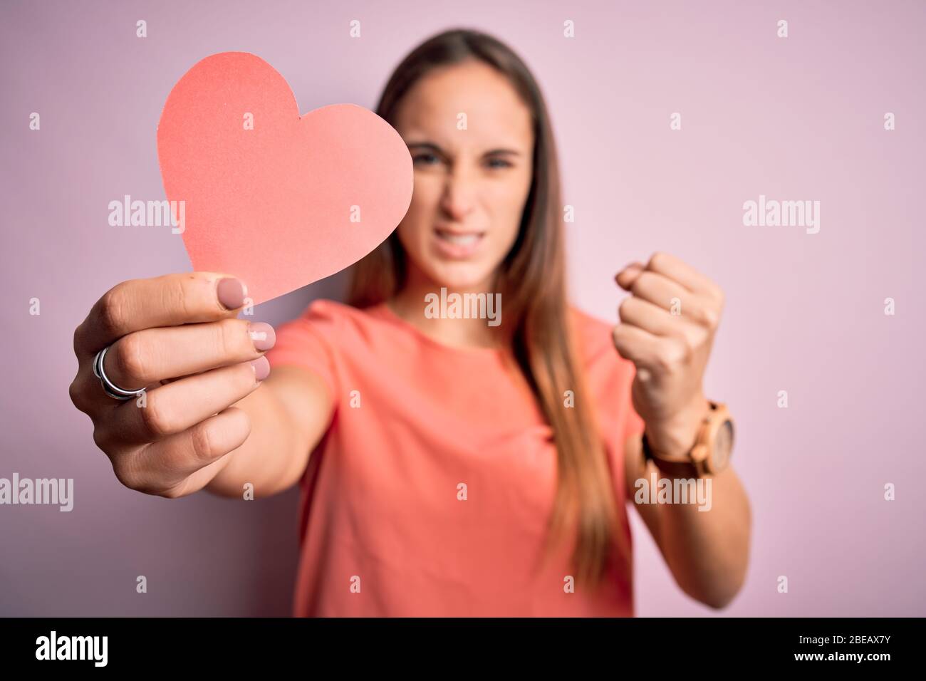 Young beautiful romantic woman holding paper heart shape over isolated ...