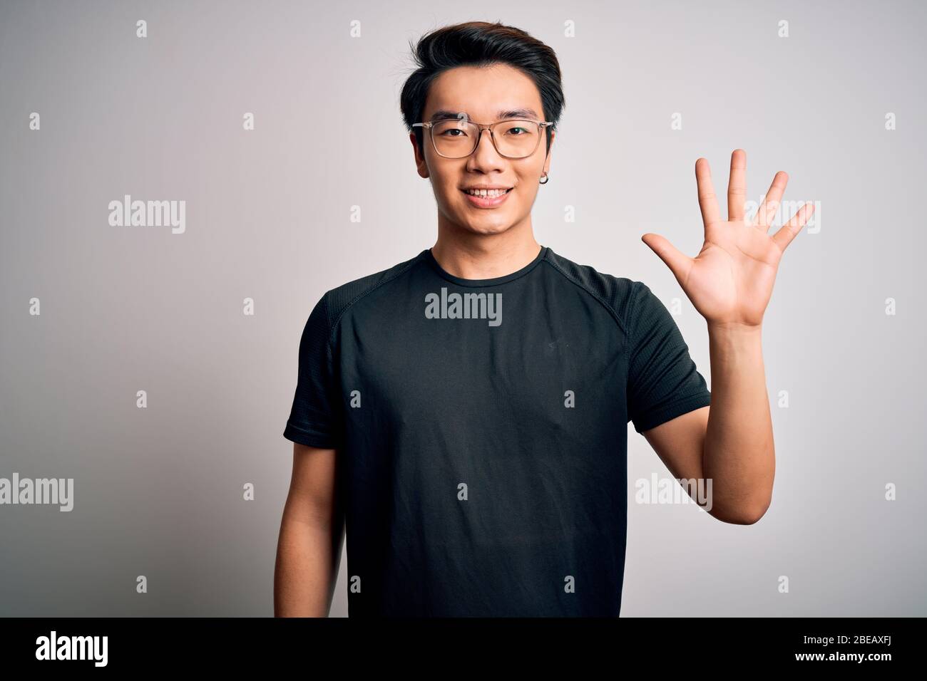 Young handsome chinese man wearing black t-shirt and glasses over white ...