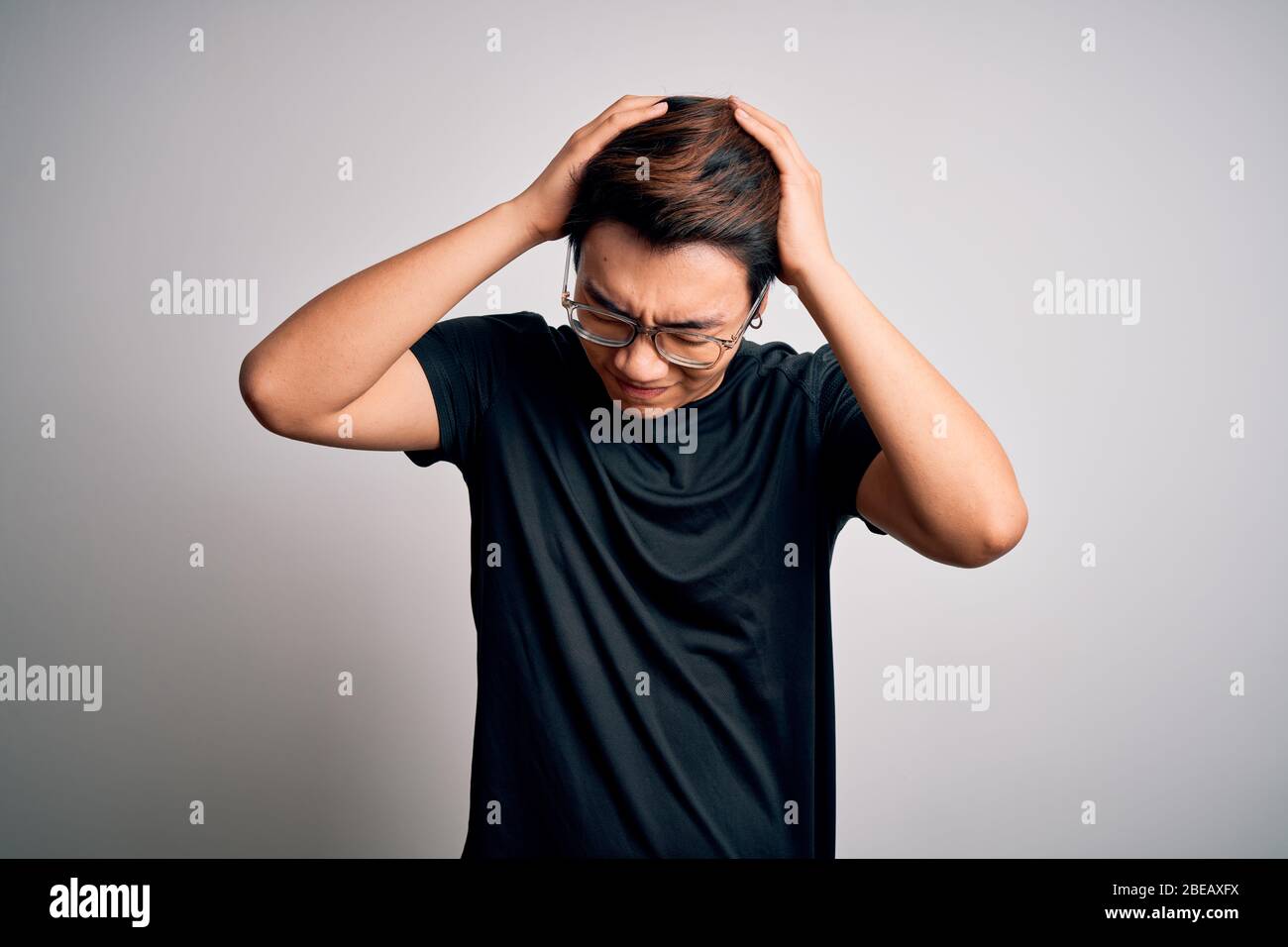 Young handsome chinese man wearing black t-shirt and glasses over white ...