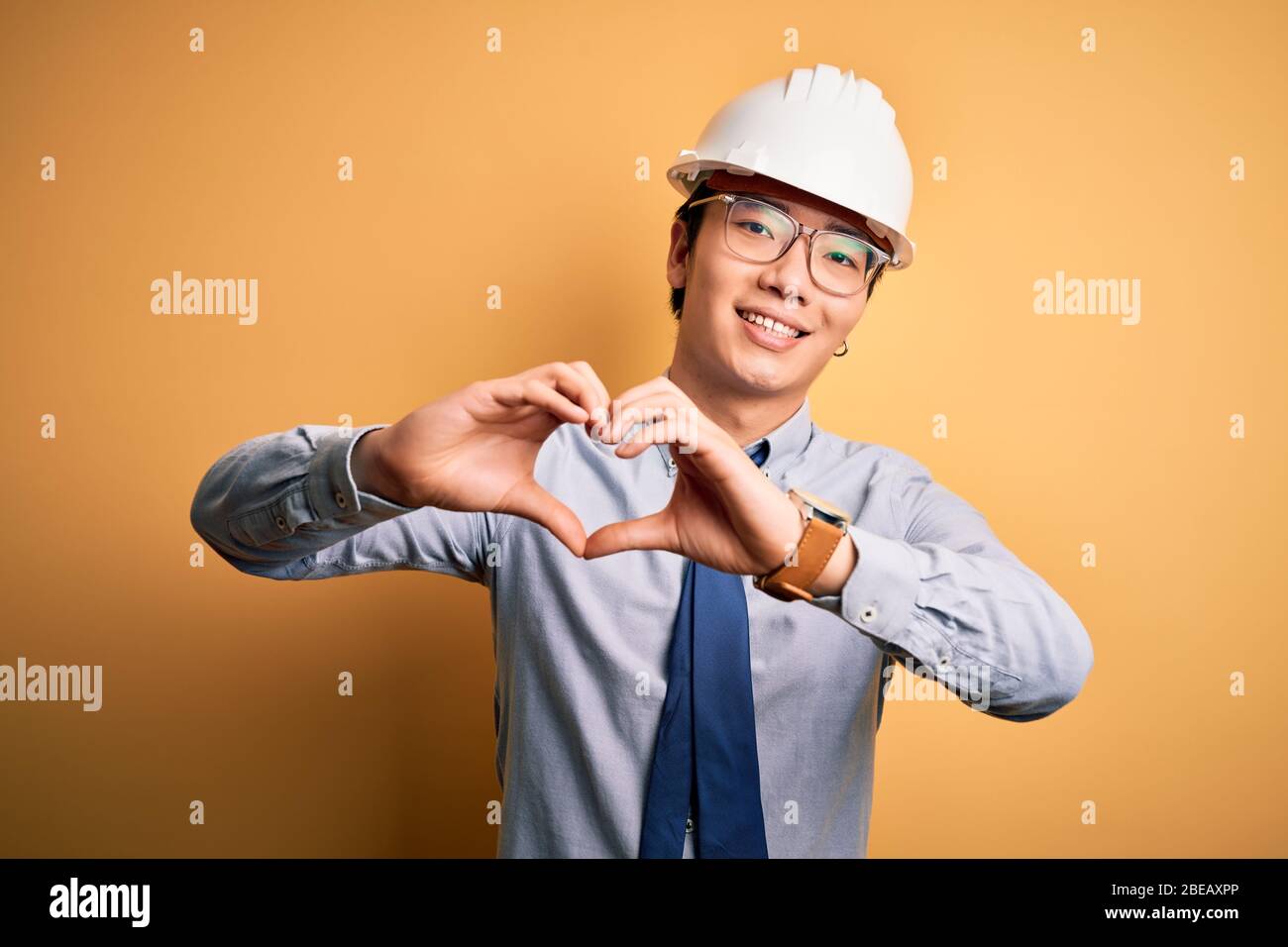 Young handsome chinese architect man wearing safety helmet and tie over ... Young handsome chinese architect man wearing safety helmet and tie over ...