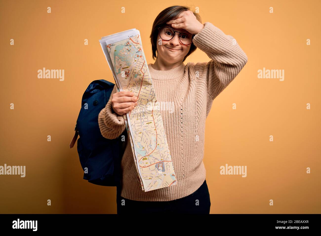 Young down syndrome tourist woman wearing bag and looking at ...