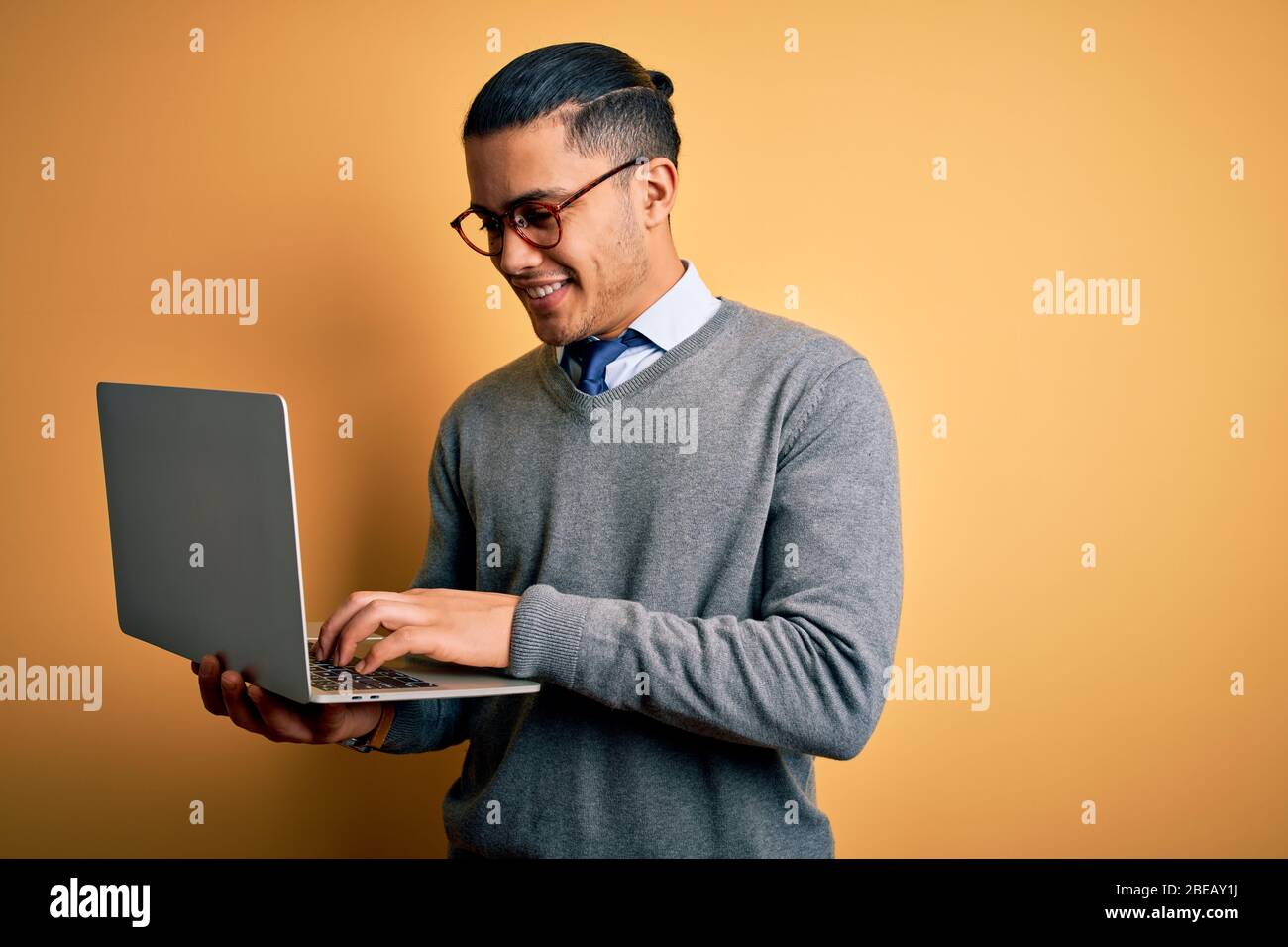 Young brazilian businessman working using laptop standing over ...