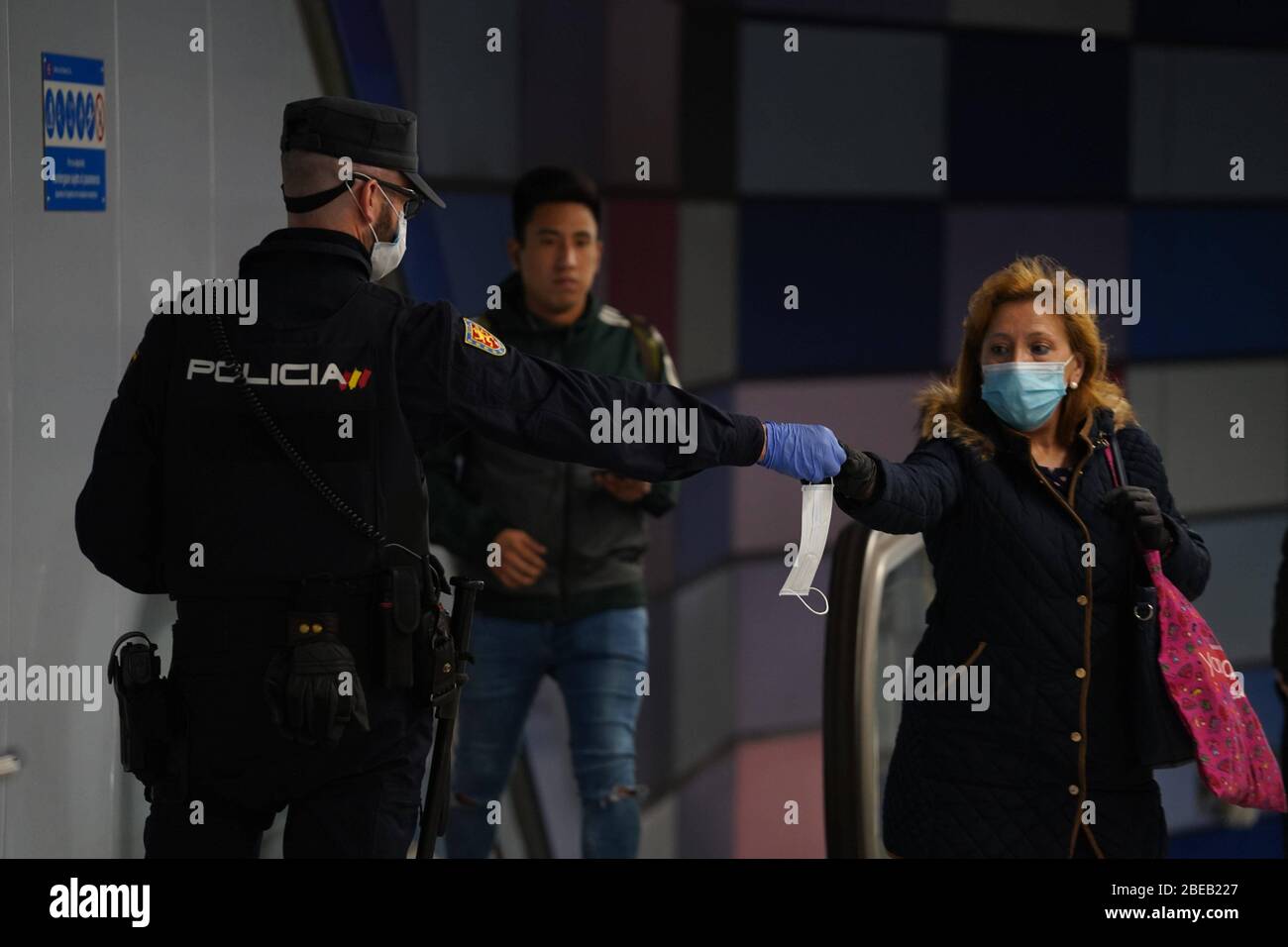 Madrid, Spain. 13th Apr, 2020. A police officer gives out free ...