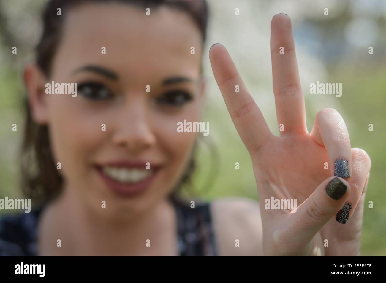 Victory Sign. Young woman doing victory sign with the hand. Happy girl ...