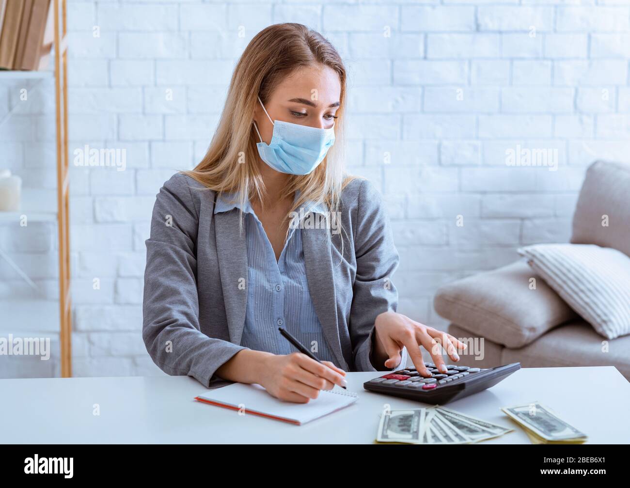Woman counts on calculator and writes in notebook Stock Photo - Alamy