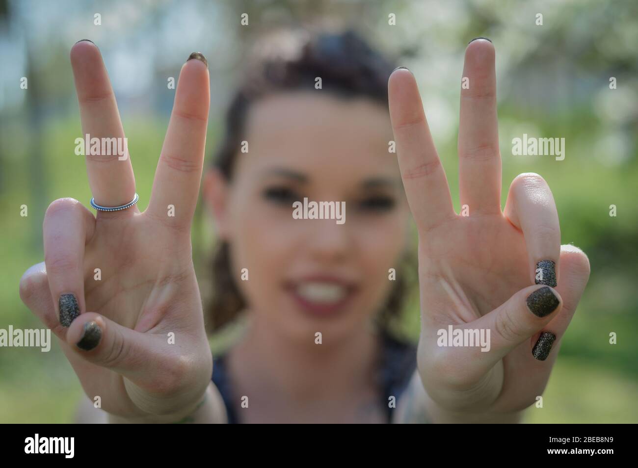 Victory Sign. Young woman doing victory sign with the hand. Happy girl ...