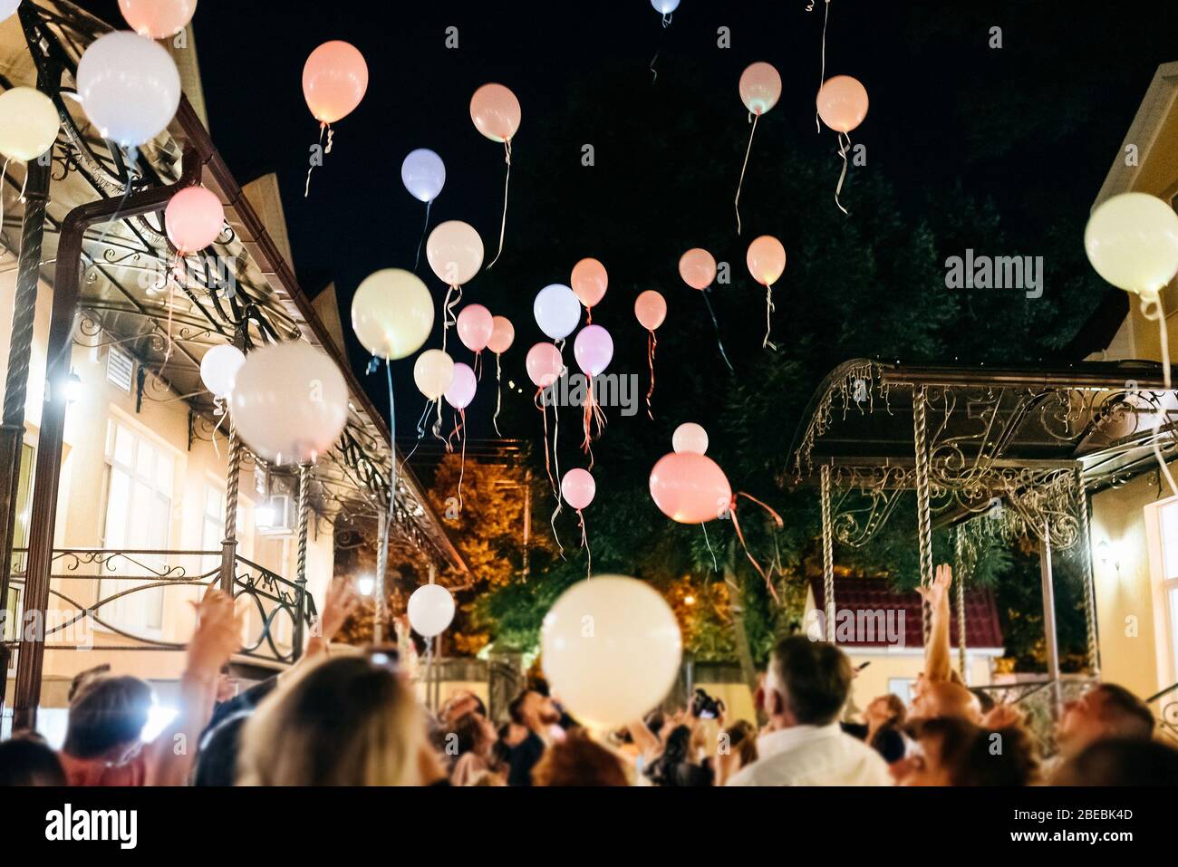 Crowd Throwing Colorful Balloons to Sky at night During Festival or ...