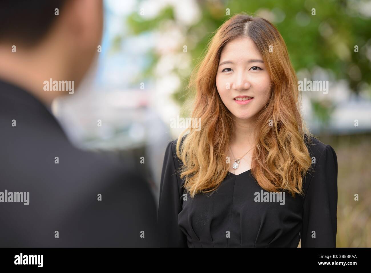 Happy young Asian business couple talking together in the city Stock ...
