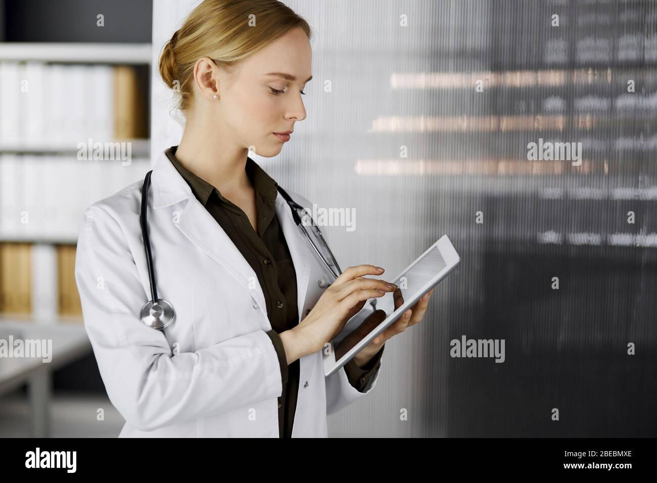 Unknown female doctor using tablet computer in clinic. Perfect medical ...