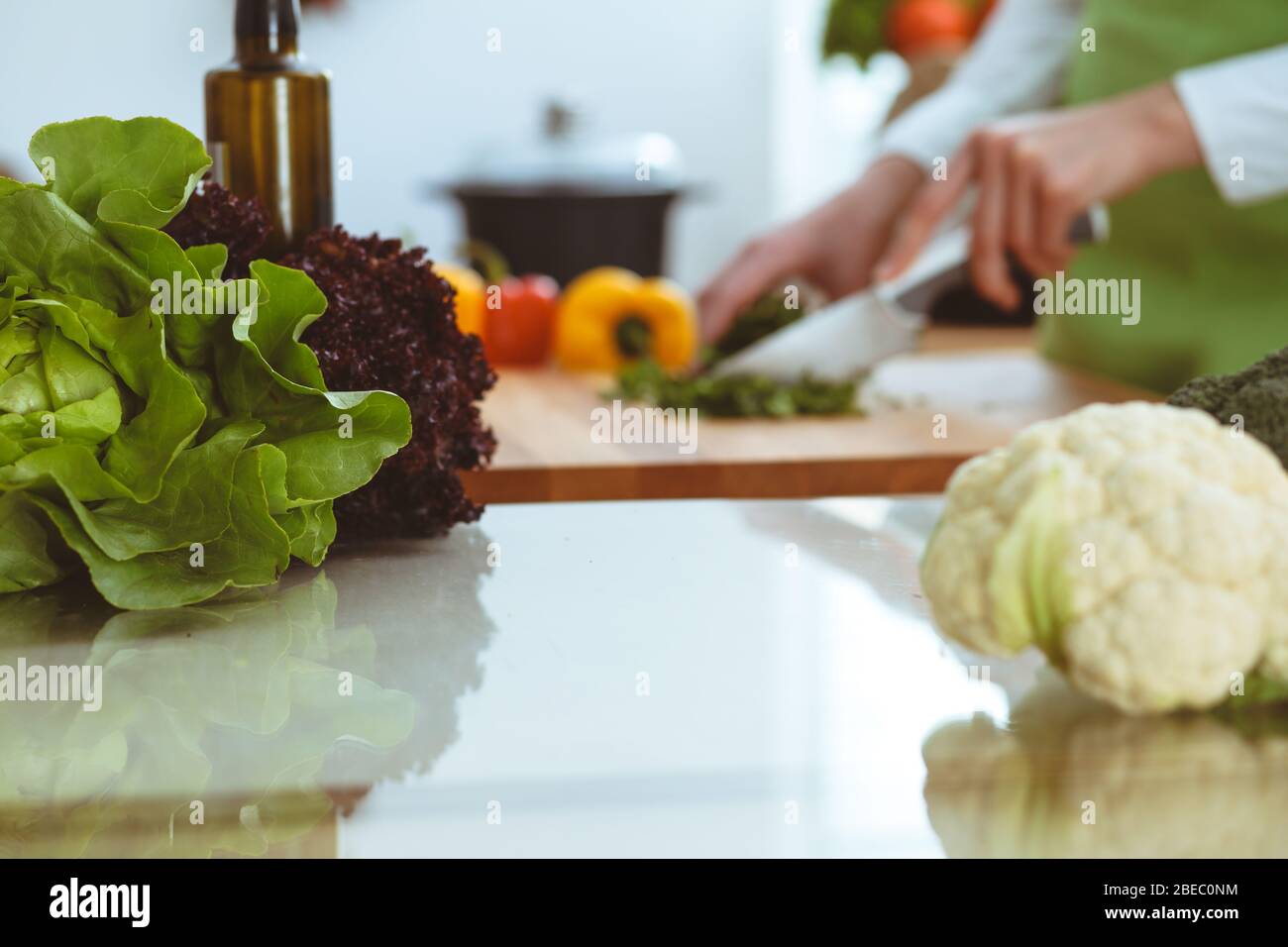 Unknown human hands cooking in kitchen. Woman is busy with vegetable ...