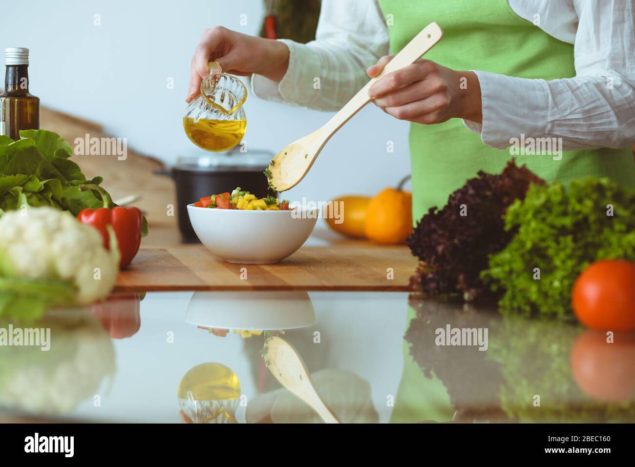 Unknown human hands cooking in kitchen. Woman is busy with vegetable ...