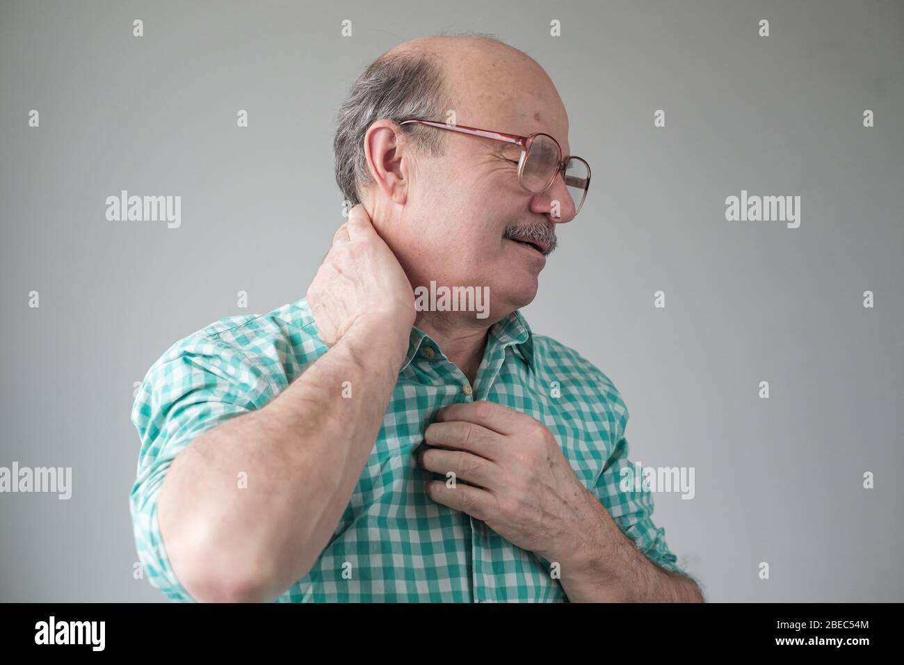 Senior hispanic man has a pain in the neck Stock Photo - Alamy