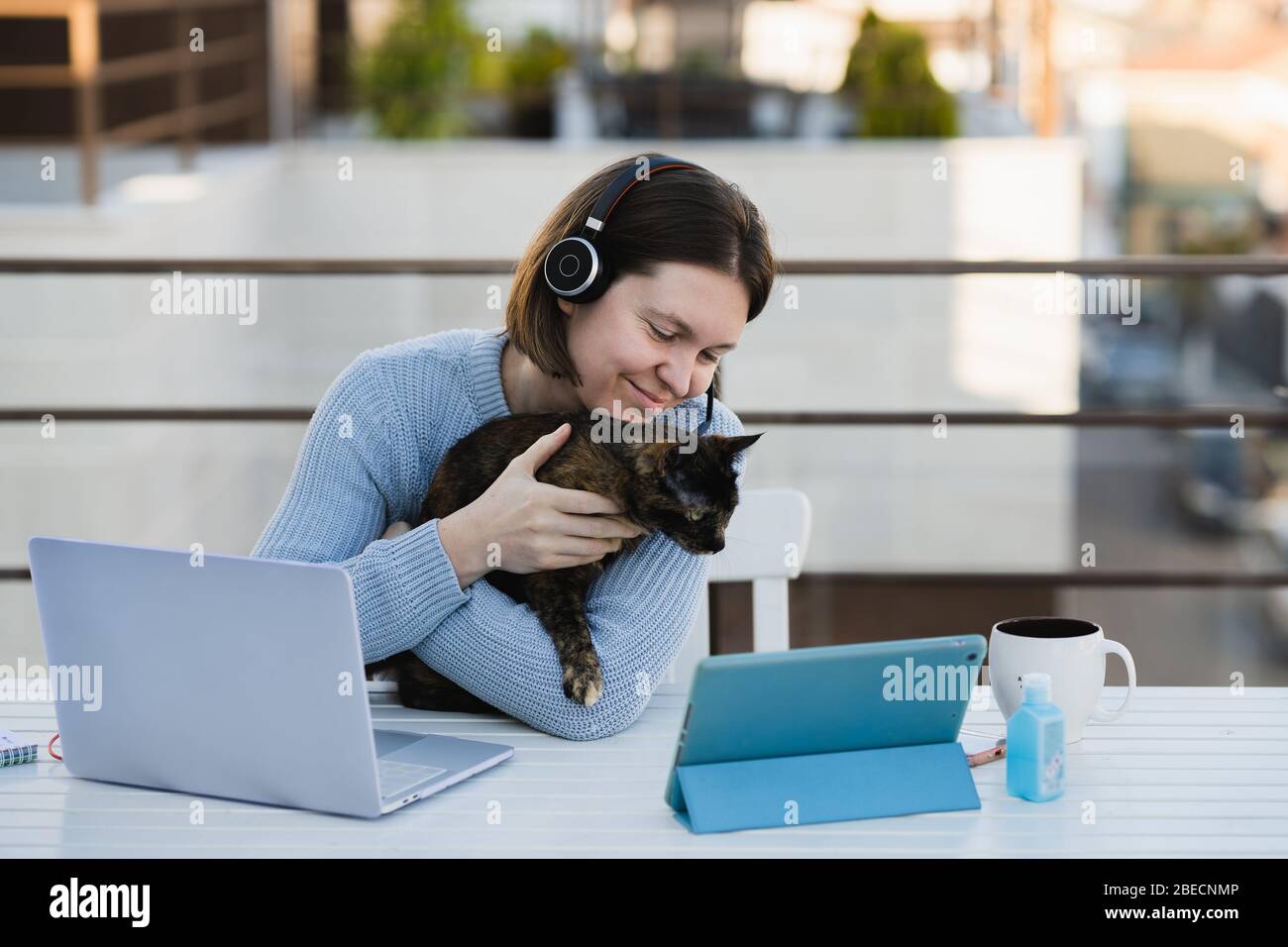 Female remote working remotely at home terrace with her pet Stock Photo ...