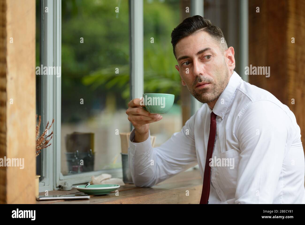 Handsome businessman thinking while drinking coffee at the coffee shop ...