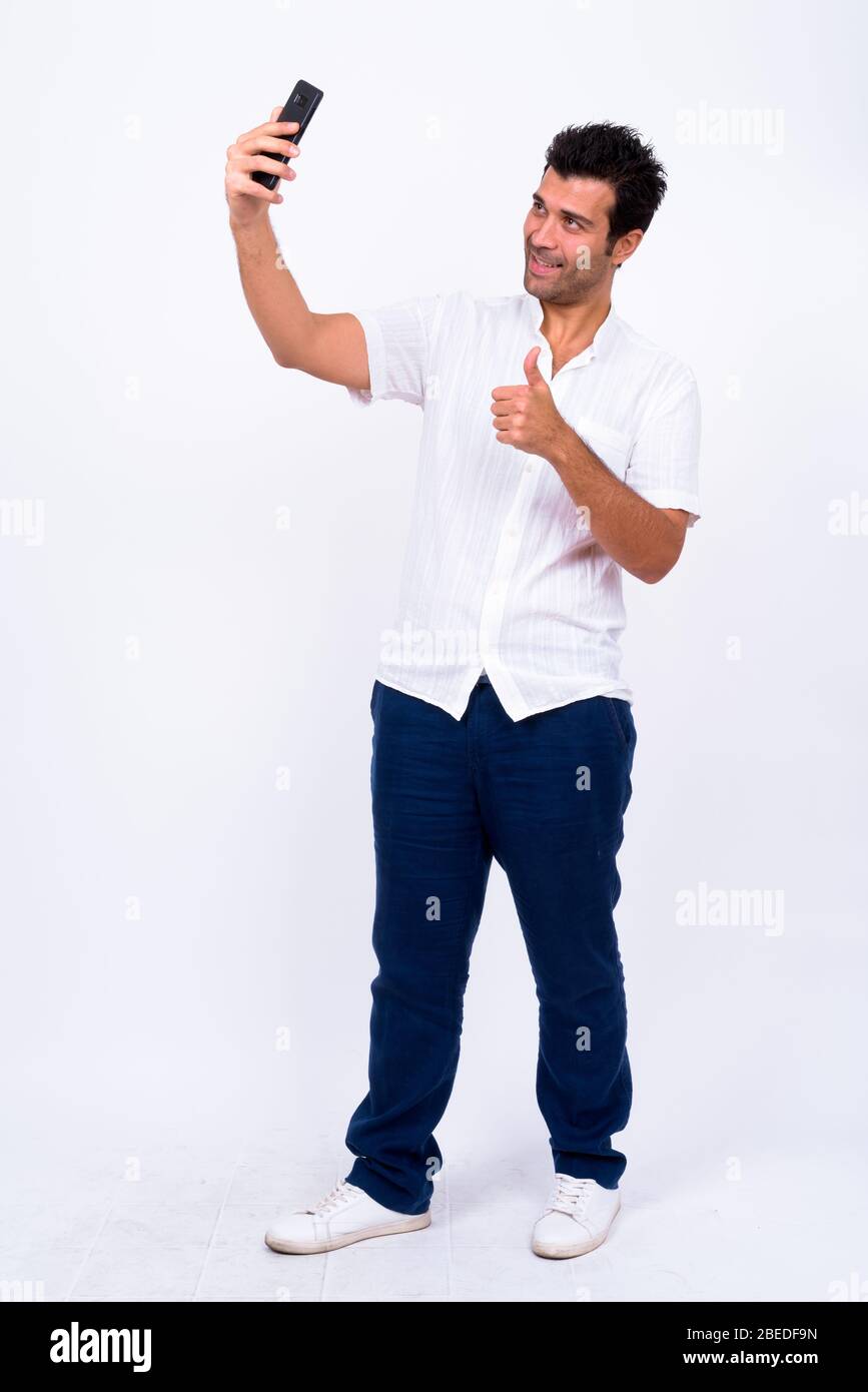Full body shot of happy handsome Turkish man taking selfie Stock Photo ...