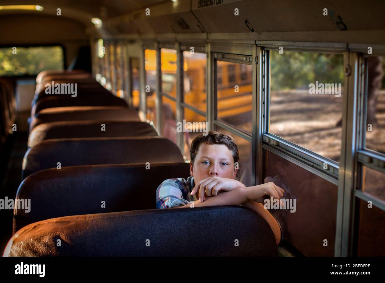 Portrait of a teenage boy sitting in an empty school bus Stock Photo ...