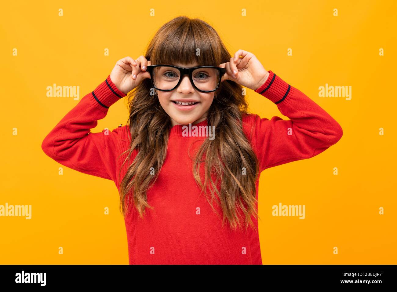cute girl in glasses on an orange studio background Stock Photo - Alamy